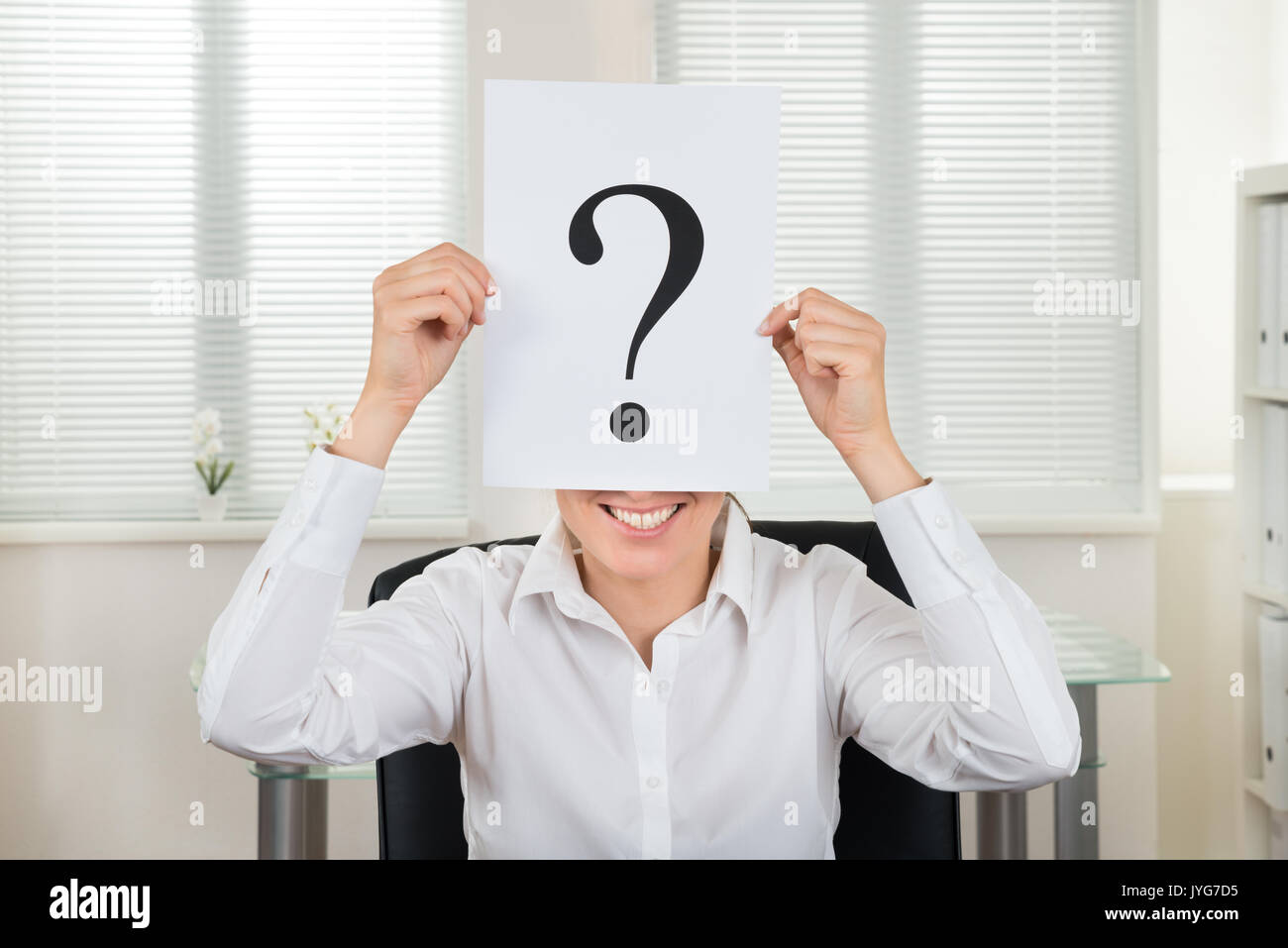 Happy Businesswoman Showing Question Mark On Paper At Desk Stock Photo ...