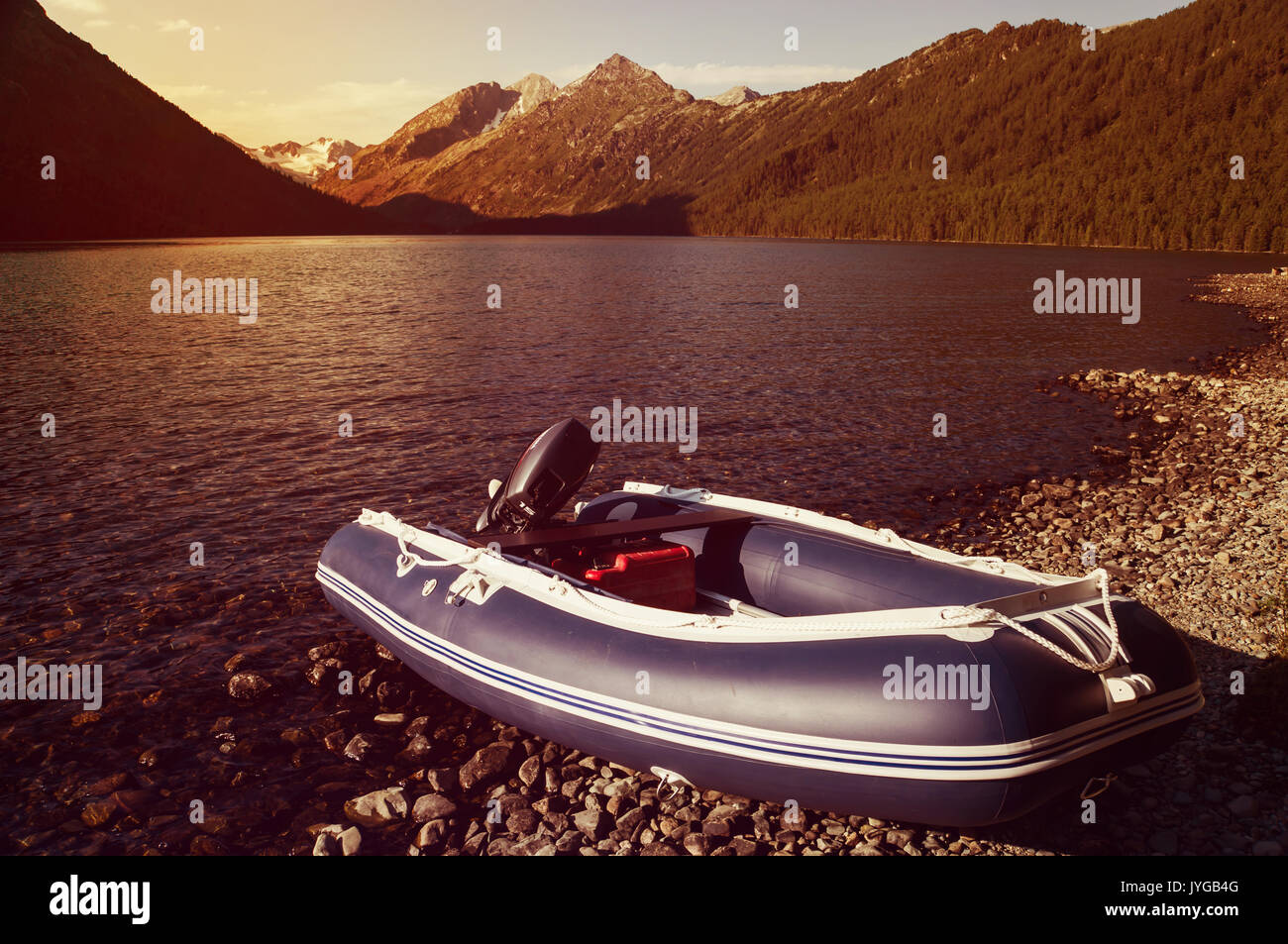 motor boat floats on the mountain'isere departing into the sunset ...