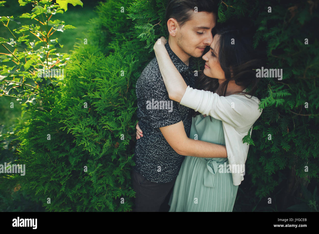 The handsome young man gently hugs and leaning his beautiful girlfriend ...