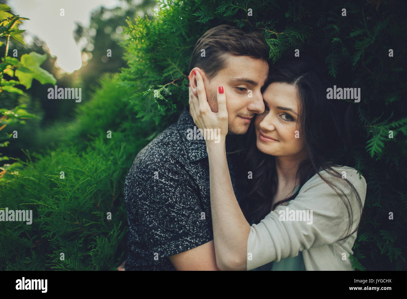 The handsome young man gently hugs and leaning his beautiful girlfriend ...