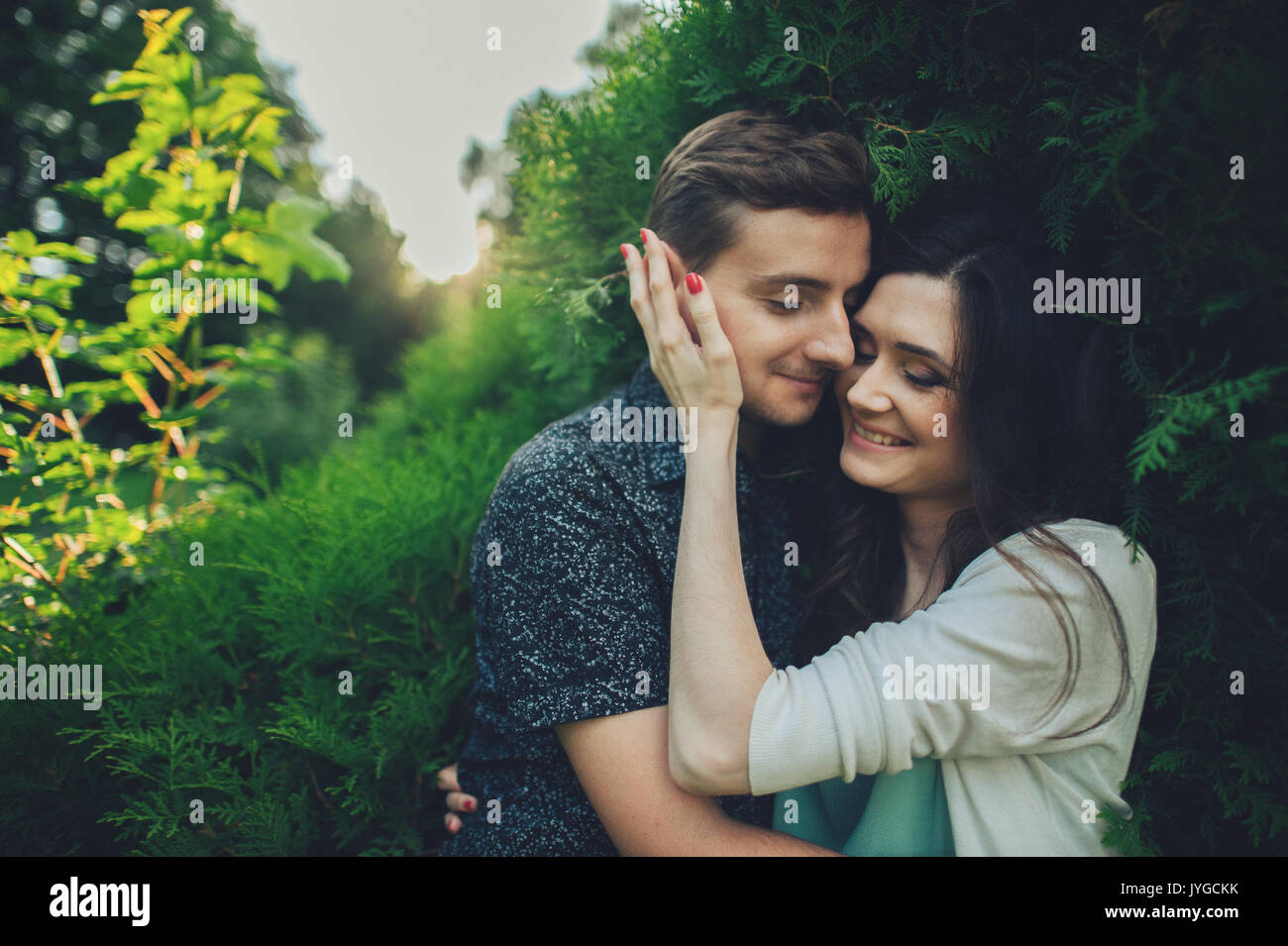 The handsome young man gently hugs and leaning his beautiful girlfriend ...
