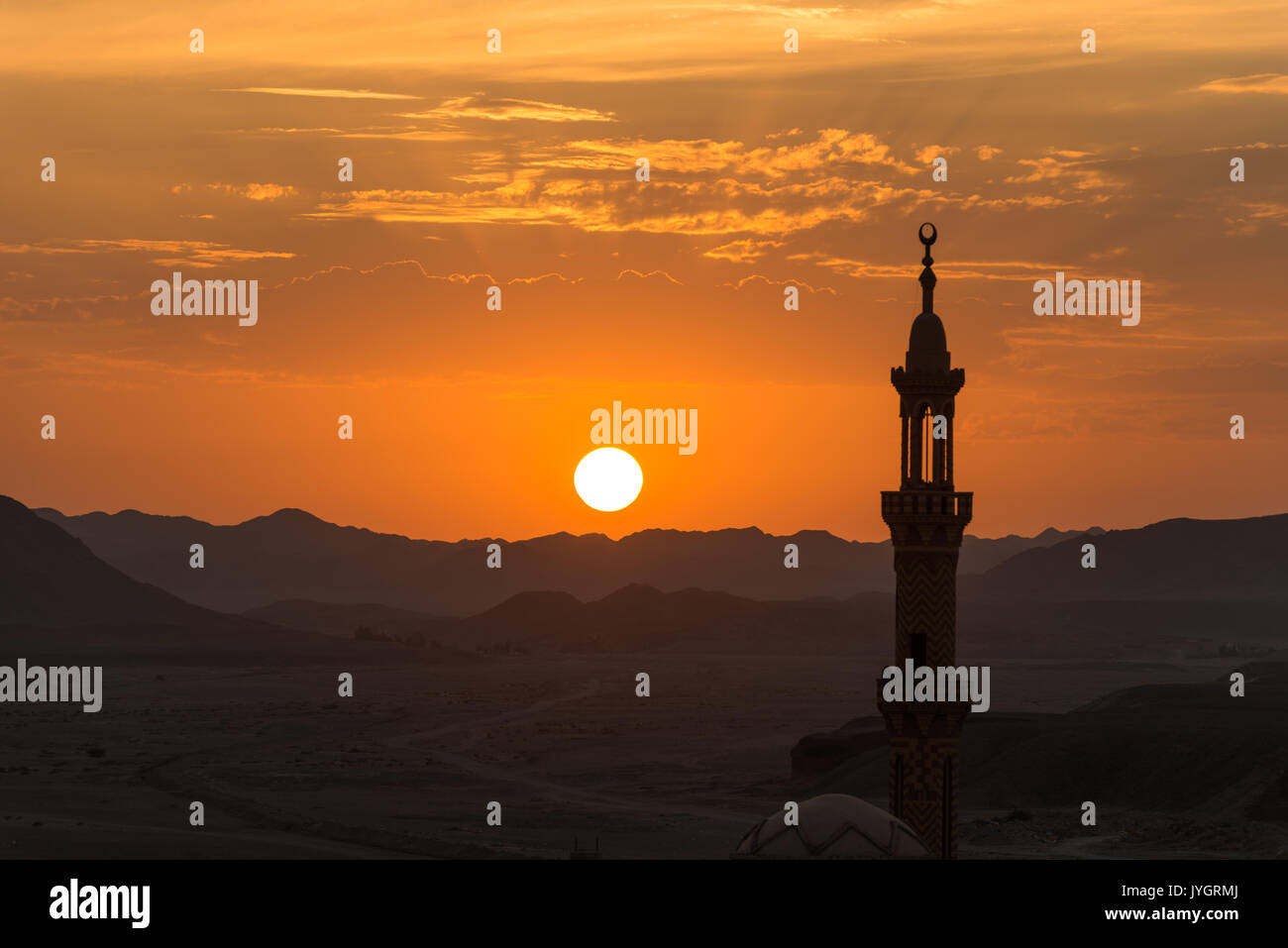Sunset with muslim mosque in foreground Stock Photo - Alamy