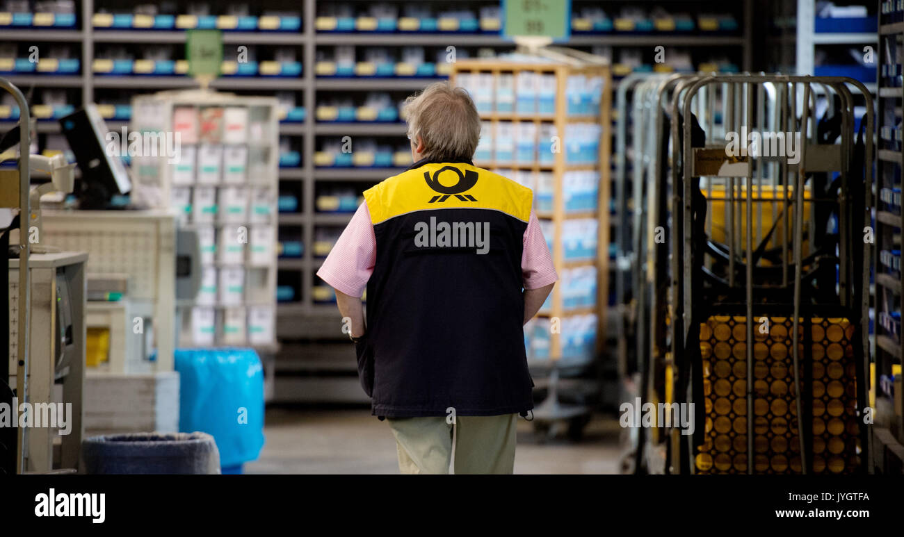 An employee of the Deutsche Post (German mail) works at the letter ...