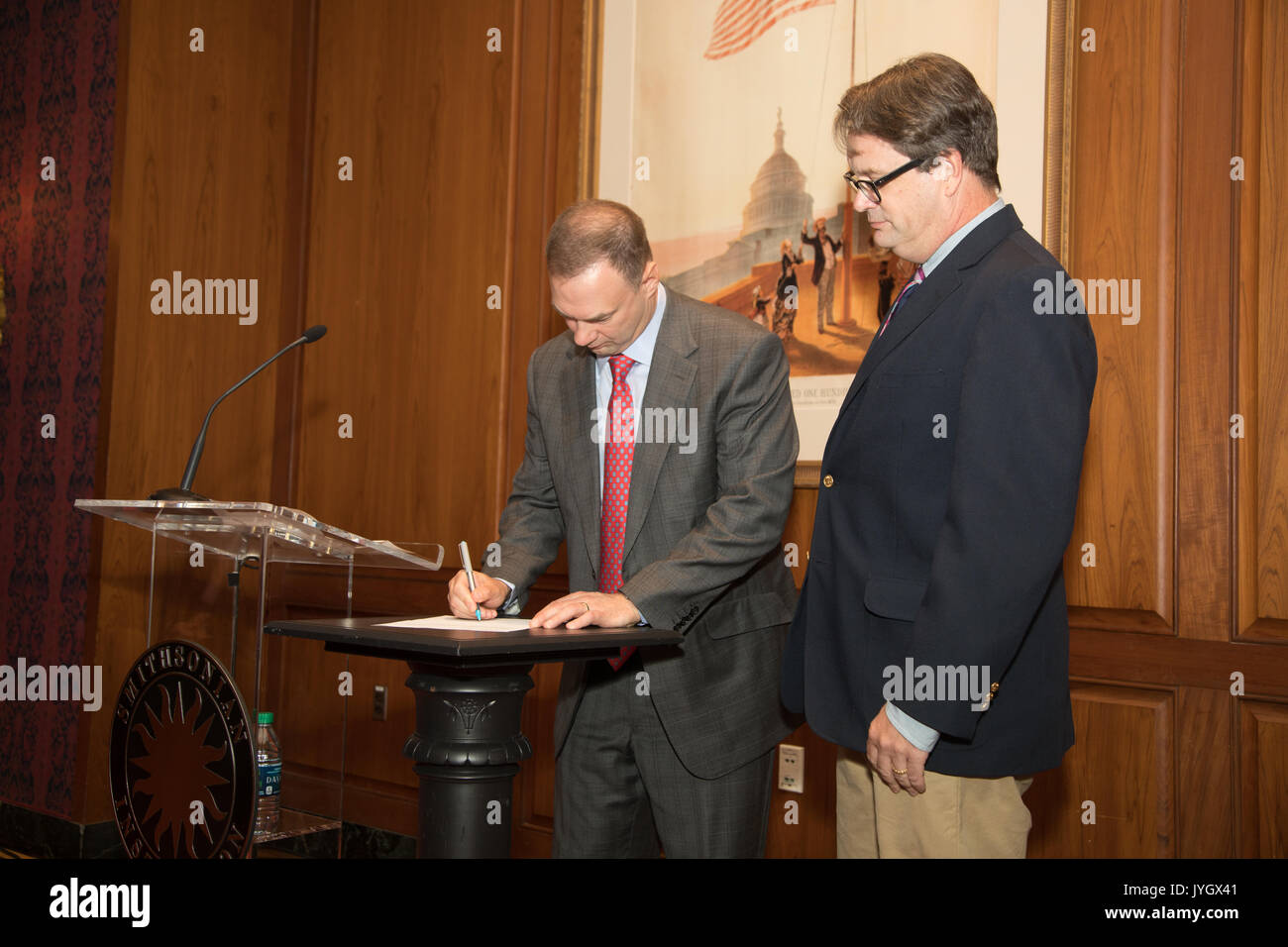 Thomas Tull (left) signs over his collection of baseball artifacts with ...