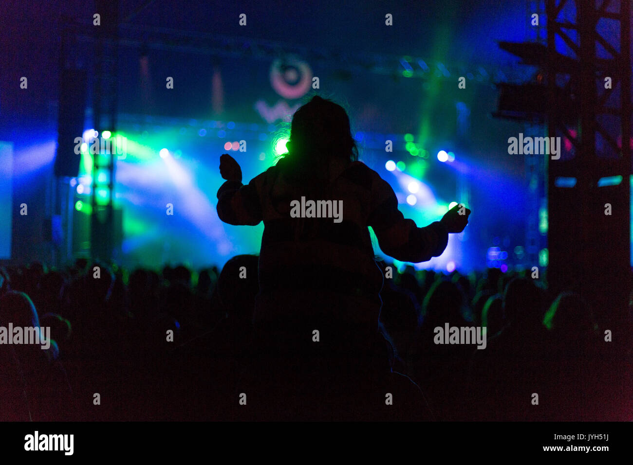 CROWD SCENE DANCING ON SHOULDERS IN SILHOUETTE: People dance wildly on ...