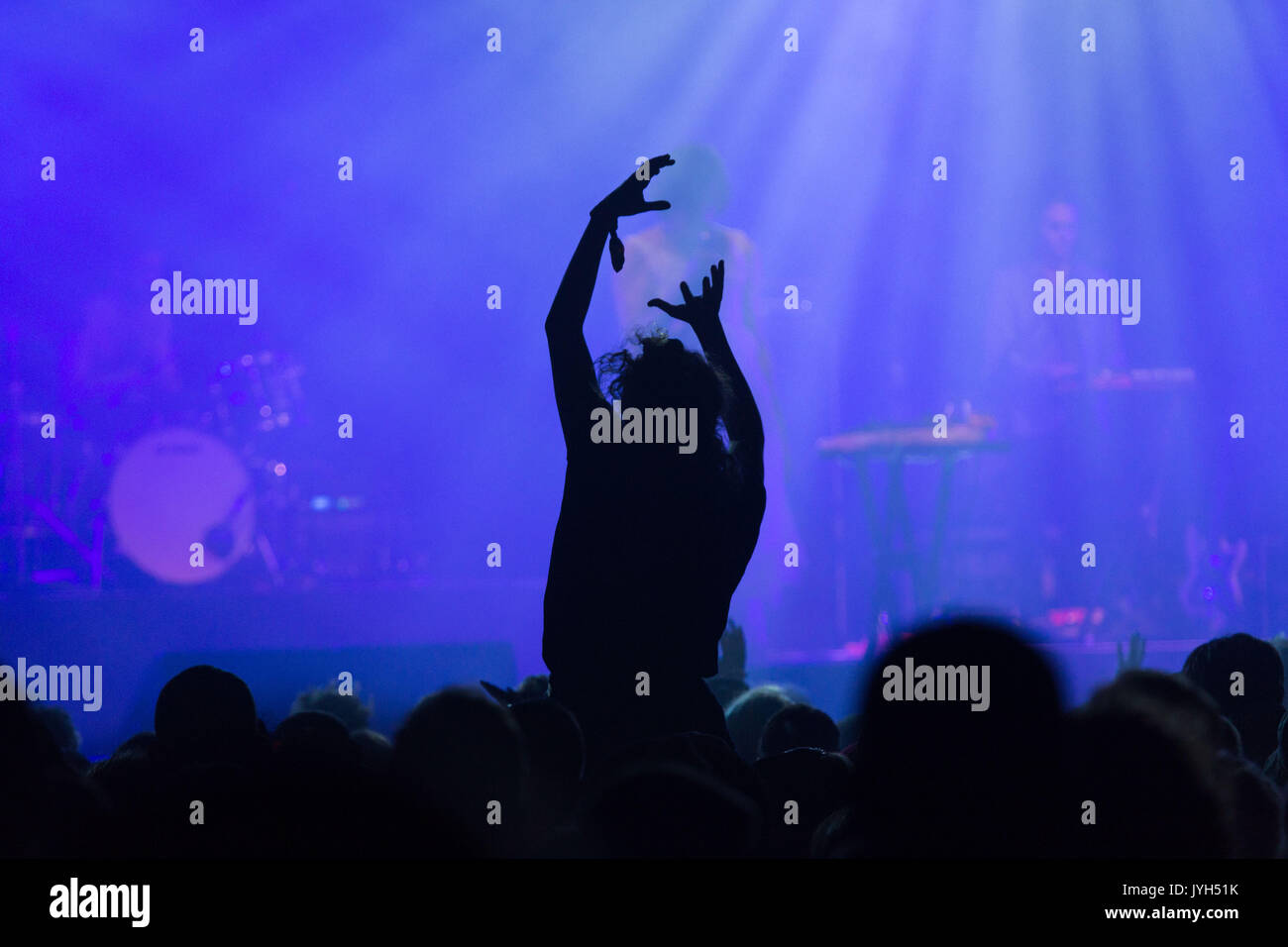 CROWD SCENE DANCING ON SHOULDERS IN SILHOUETTE: People dance wildly on ...