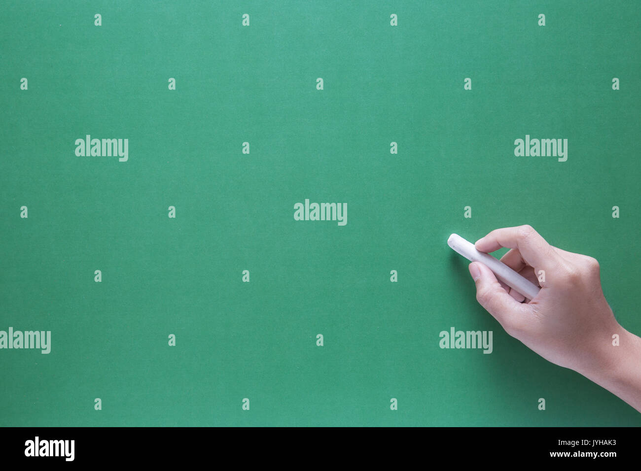 hand holding chalk with green chalk board background Stock Photo - Alamy