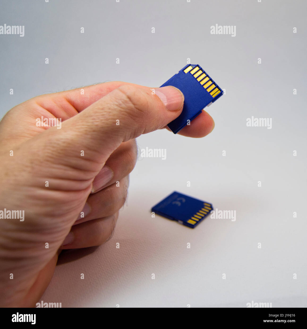 man hand holding a memory card on a white background. for information ...
