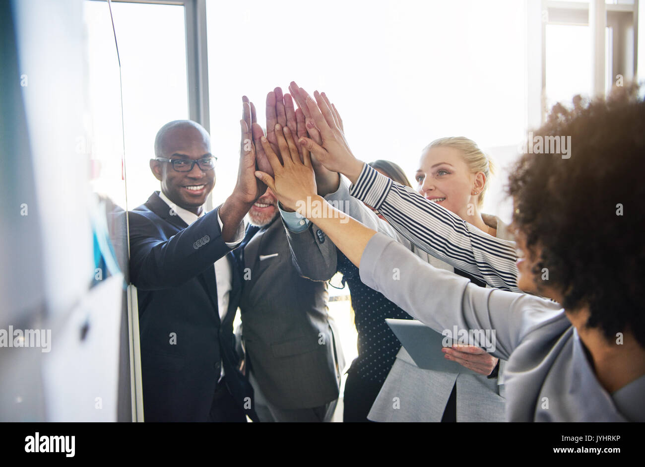 Professional colleagues high fiving hi-res stock photography and images ...