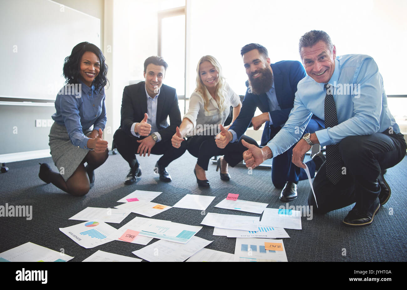 Portrait of a diverse group of smiling corporate executives giving the ...