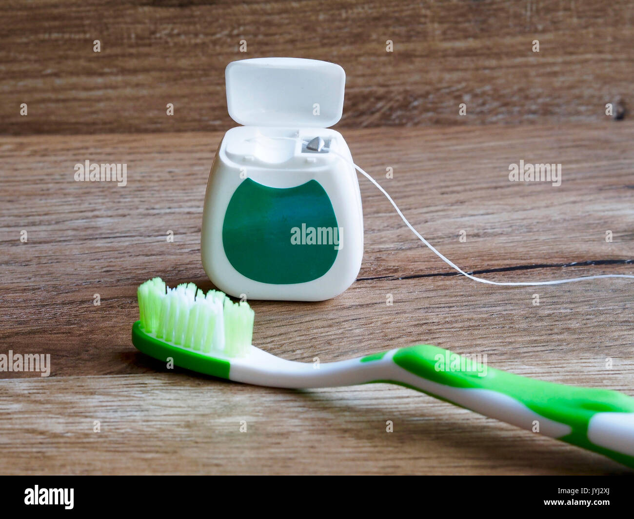 Dental floss and toothbrush on wood background Stock Photo - Alamy