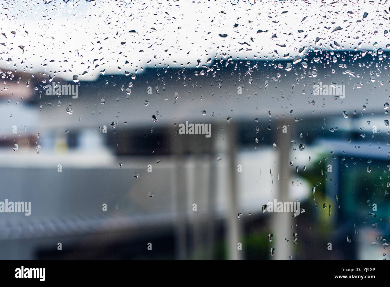 Drops of rain on a window glass, Through the window view of overcast ...