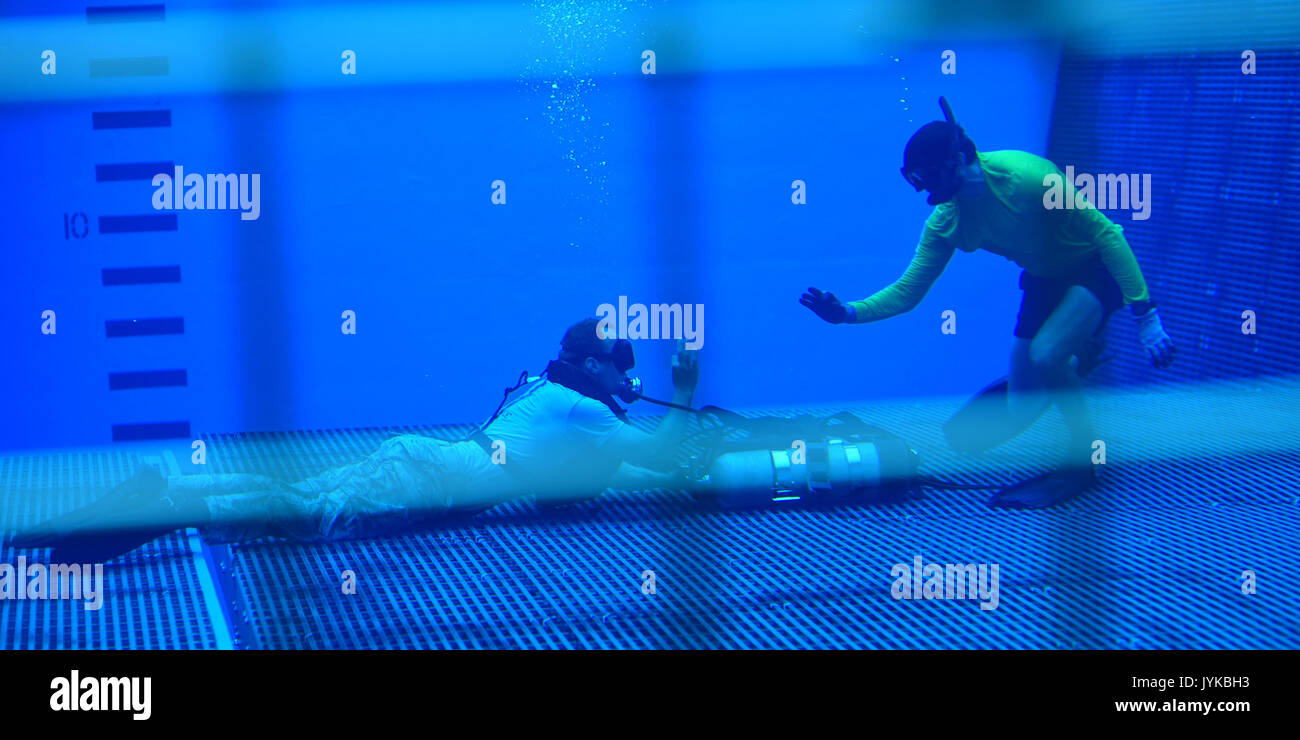 A Naval Diving and Salvage Training Center instructor signals to one of ...