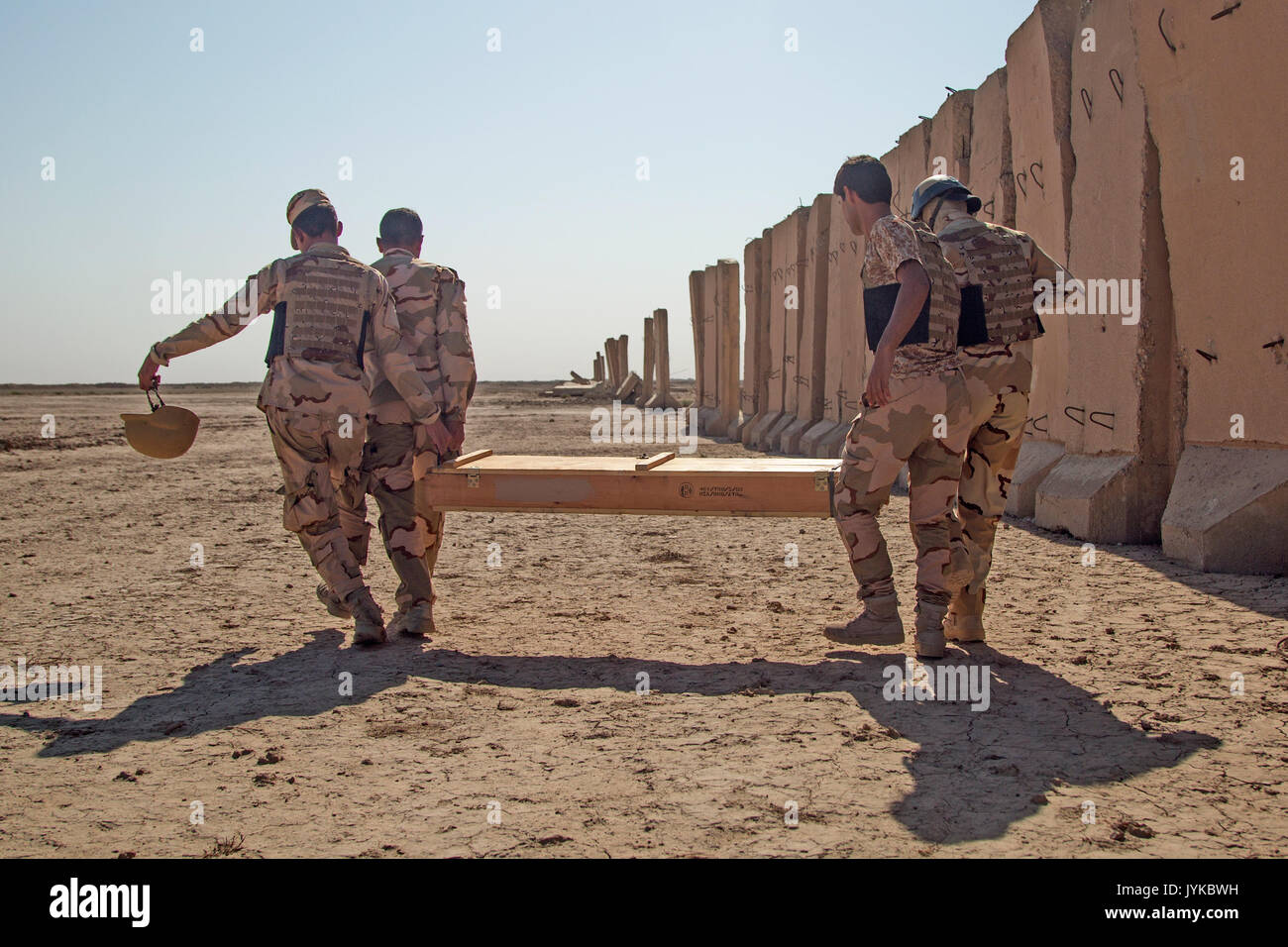 Iraqi security forces members carry a box of explosives during combat ...