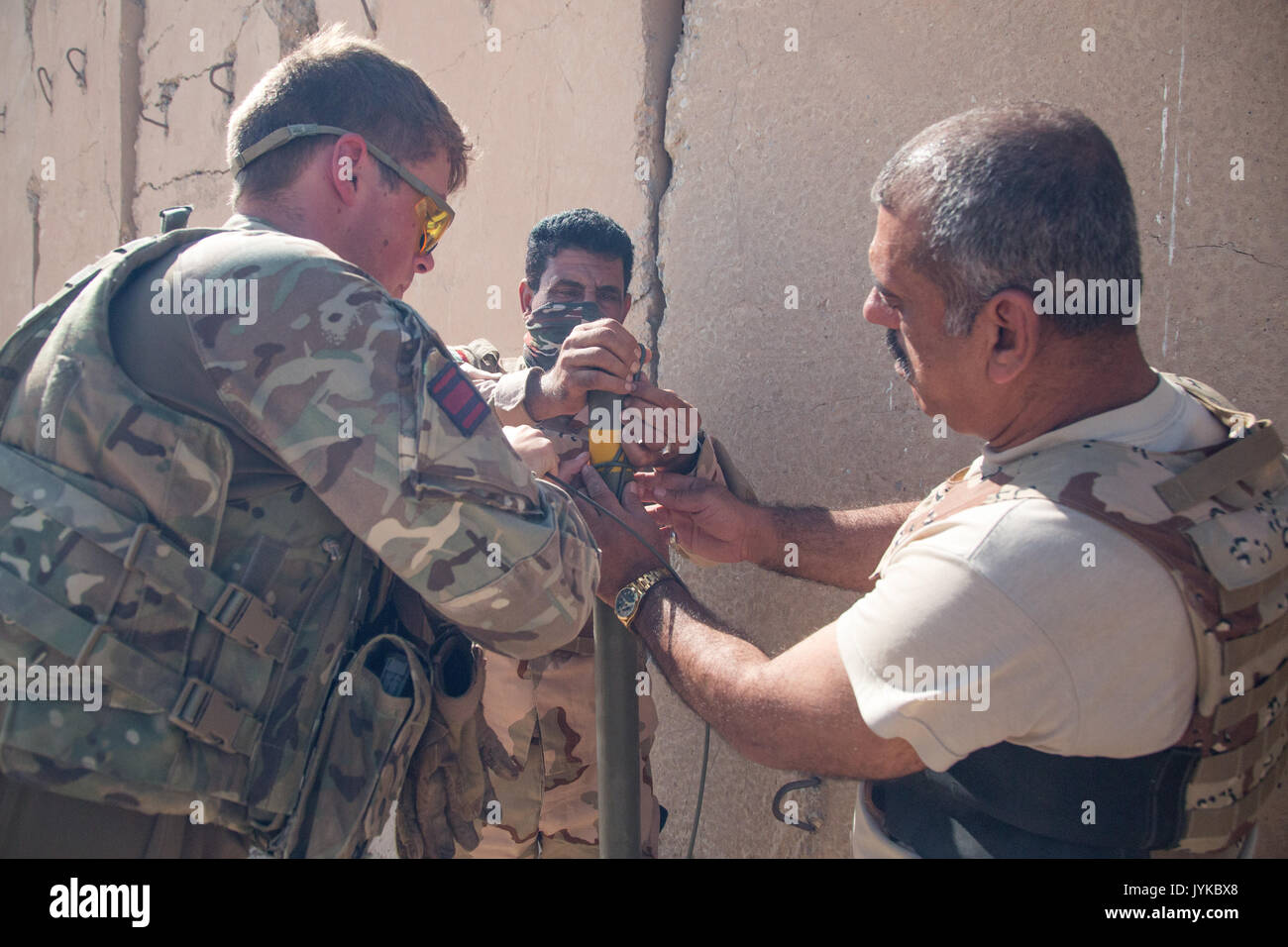 Iraqi security forces members receive assistance from a British army ...