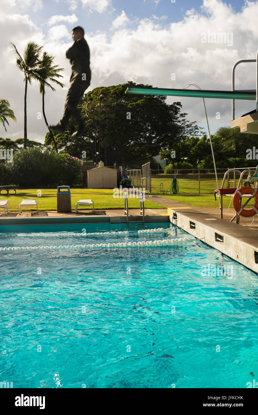 A U.S. Marine jumps into a pool during annual swim qualification aboard ...