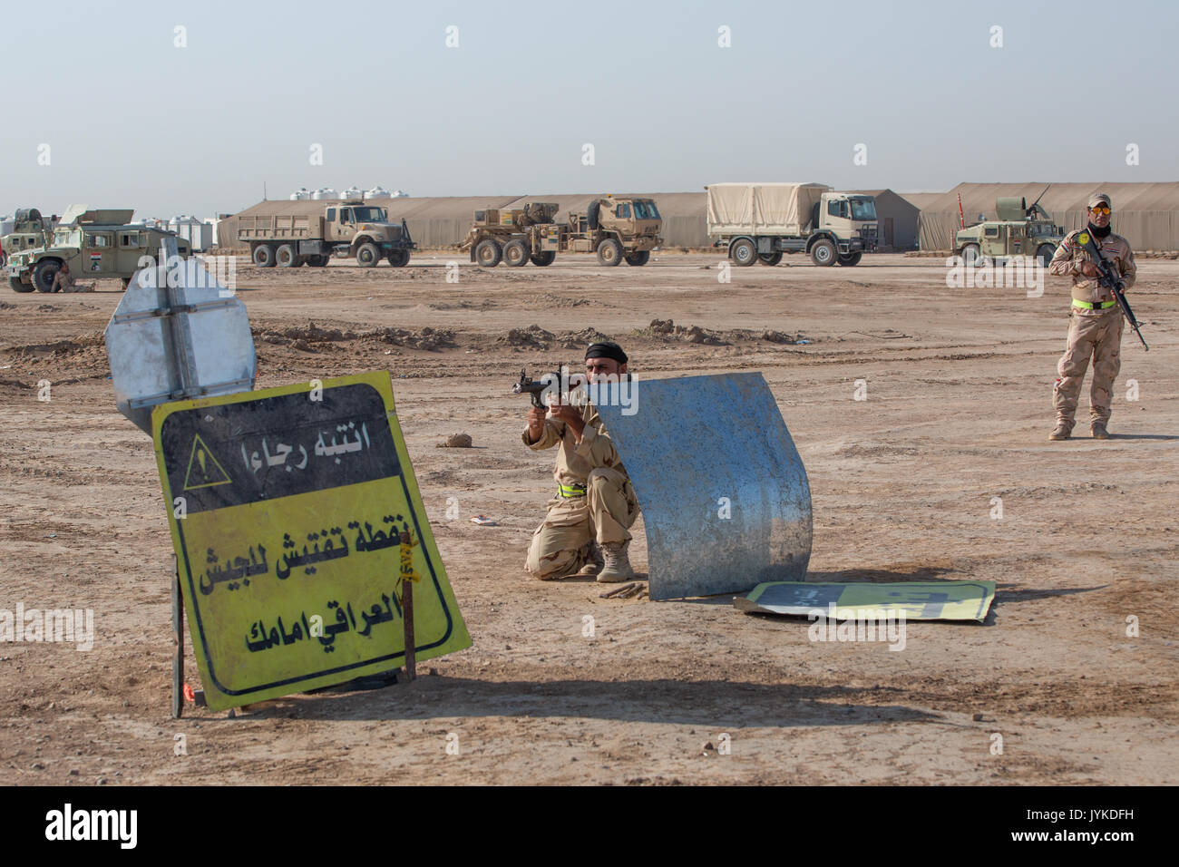 Iraqi security forces prepare for an approaching vehicle during ...