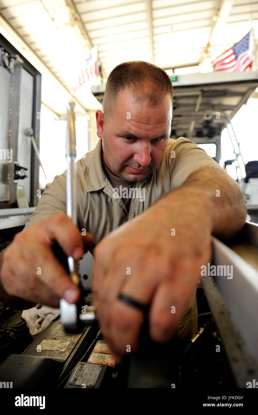 A Coast Guardsman with Port Security Unit 305 services an engine on a ...
