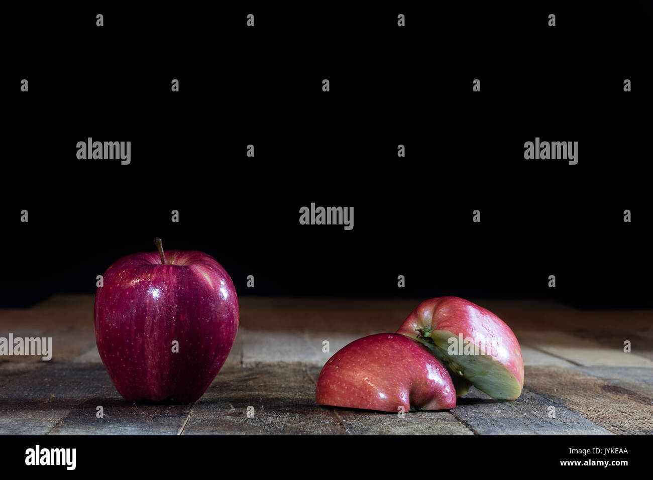 Red tasty wet apple on a wooden table. Black background Stock Photo - Alamy