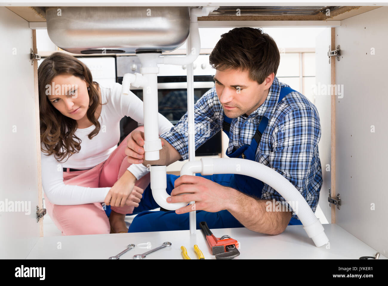 Woman fixing plumbing under sink hi-res stock photography and images ...