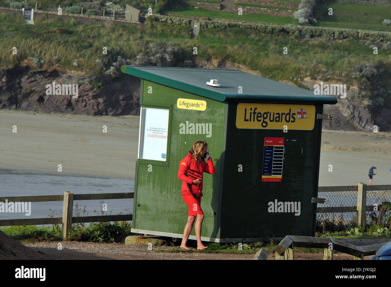 RNLI lifeguards at Polzeath In Cornwall on the beach keeping a lookout ...