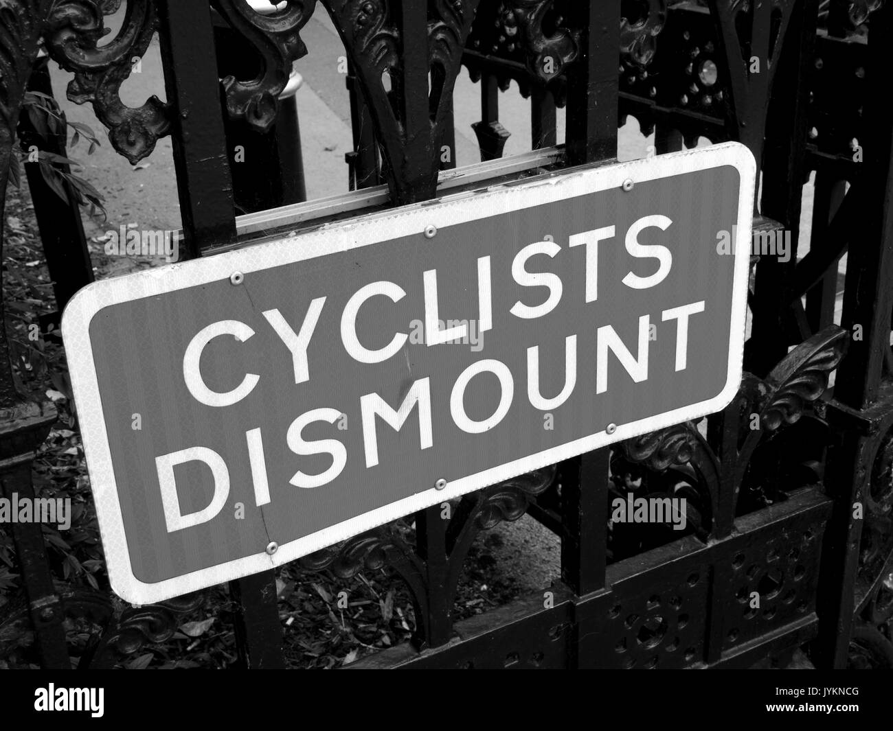 Cyclist dismount highway information sign mounted on iron railings ...