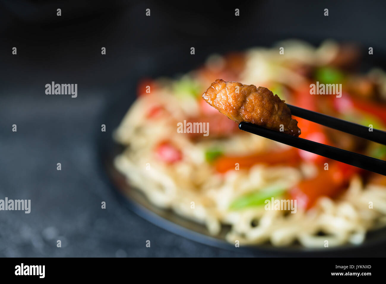 Szechuan stir fried spicy pork hold with chop sticks. Chinese food or ...
