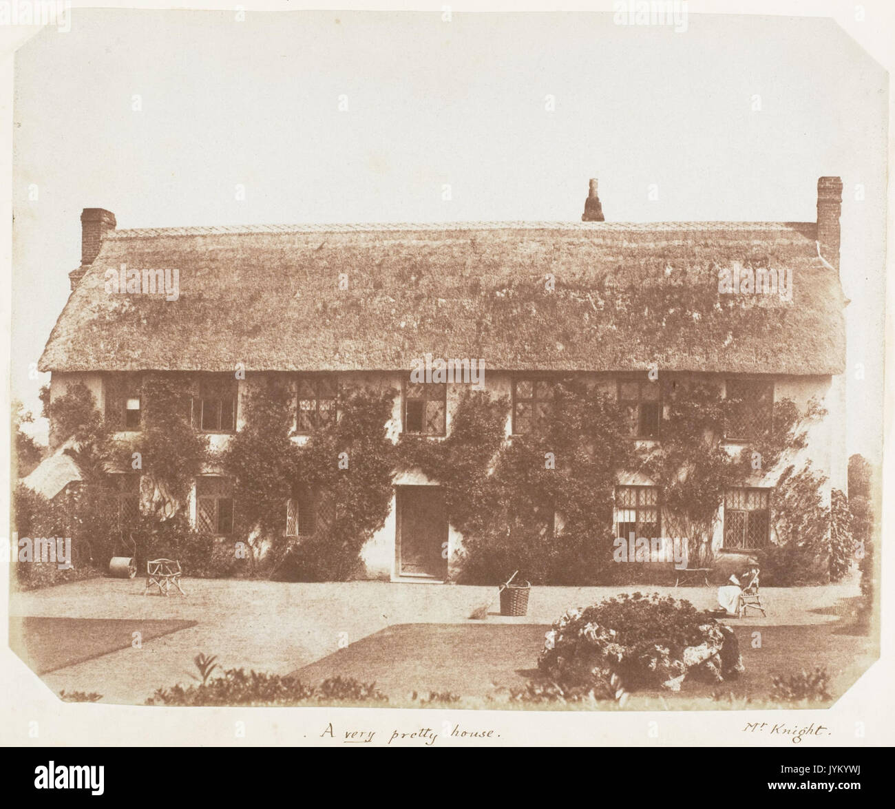 This charming photograph features a beautifully preserved house ...