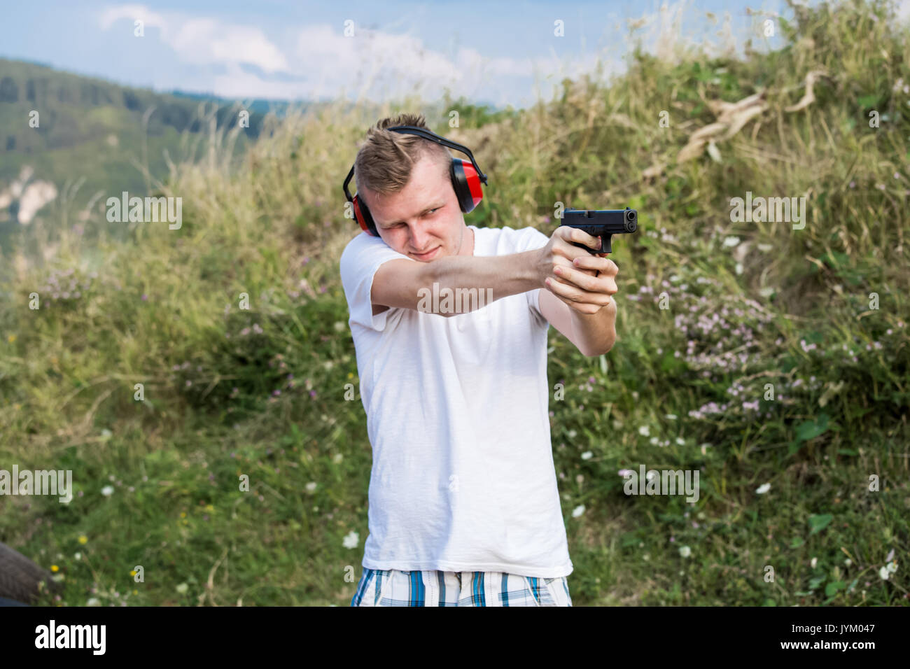 Young handsome blonde guy training policeman special forces shooting ...