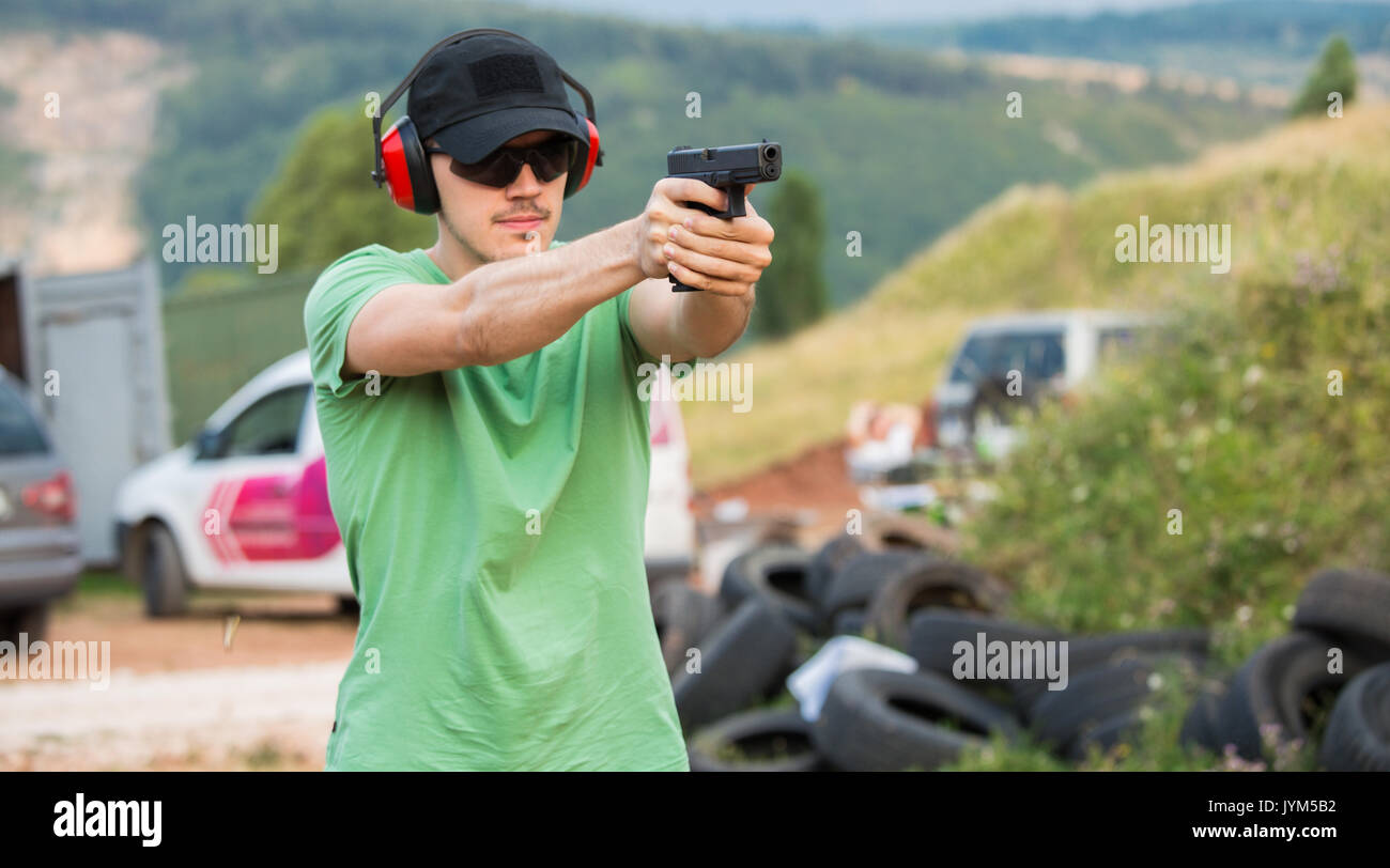 Handsome young guy wants to shoot enemy target in the wilderness with ...