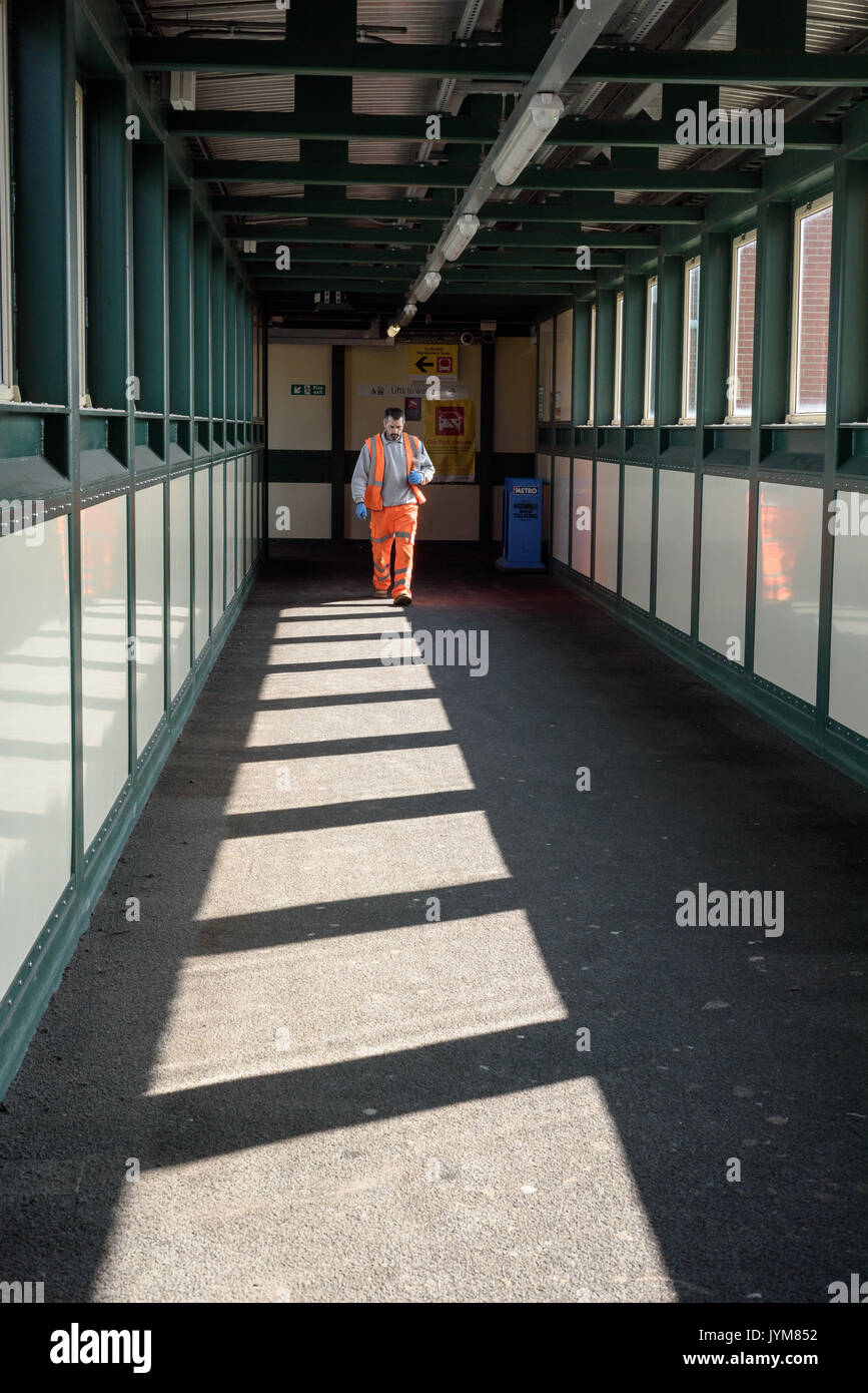 Train engineer walking on a platform crossing wearing bright orange ...