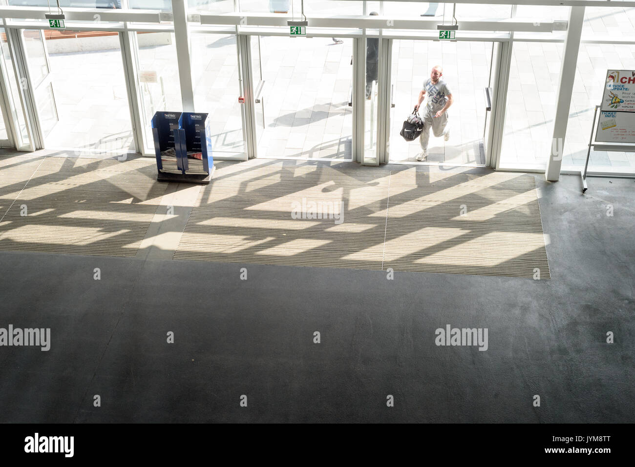 Man running through train ticket entrance to catch a train Stock Photo ...