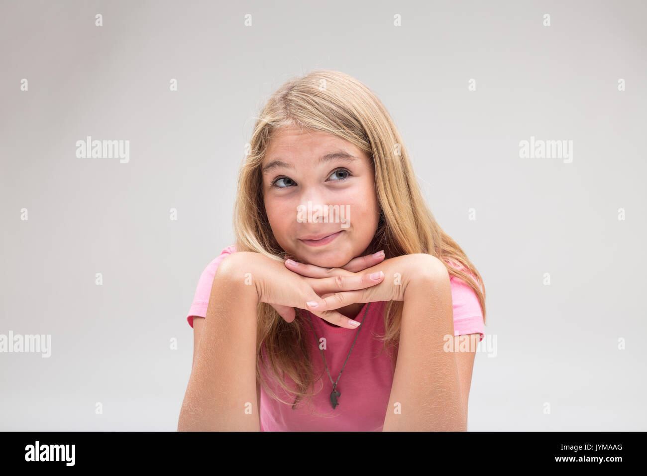 little girl looking up while she dreams about something funny or she ...