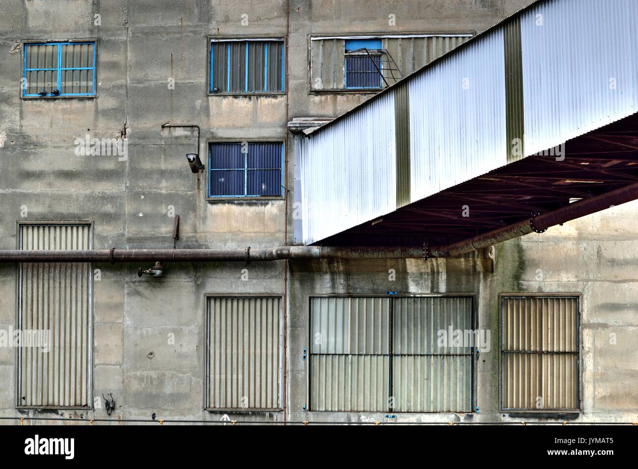 Old factory facade with corrugated sheets and covered conveyor Stock ...
