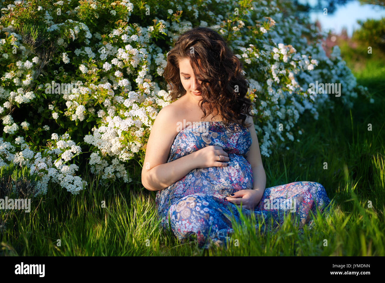Relaxed calm pregnant woman in third trimester in park with eyes closed ...