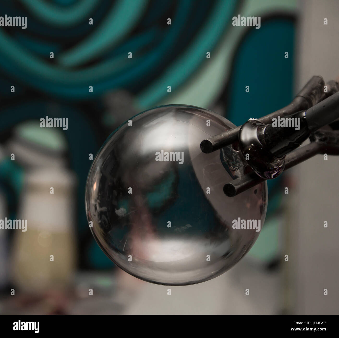 Handmade figure of melted glass, a glass blower working molten glass on ...