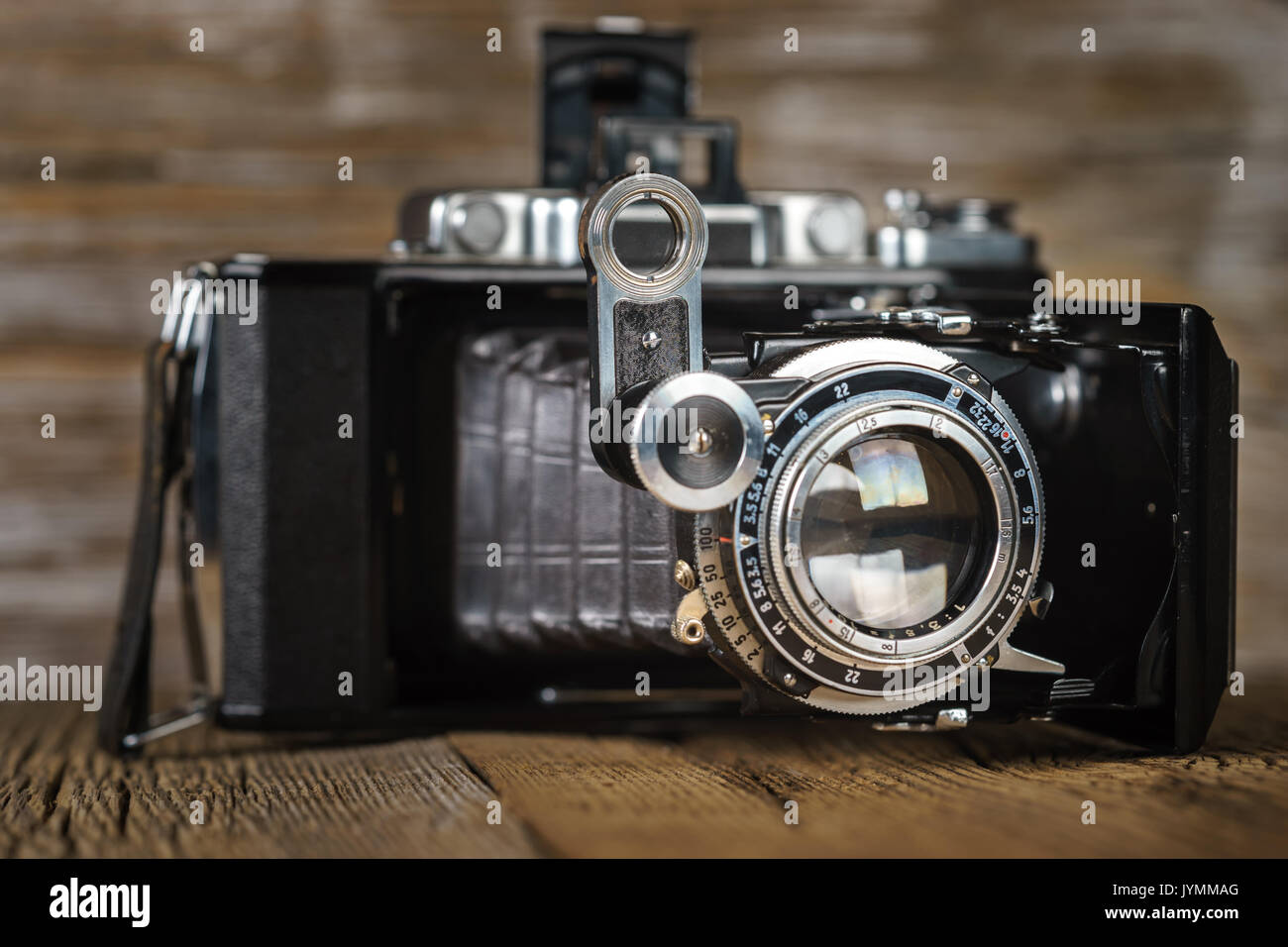 old folding camera on a textured rustic wooden surface Stock Photo - Alamy