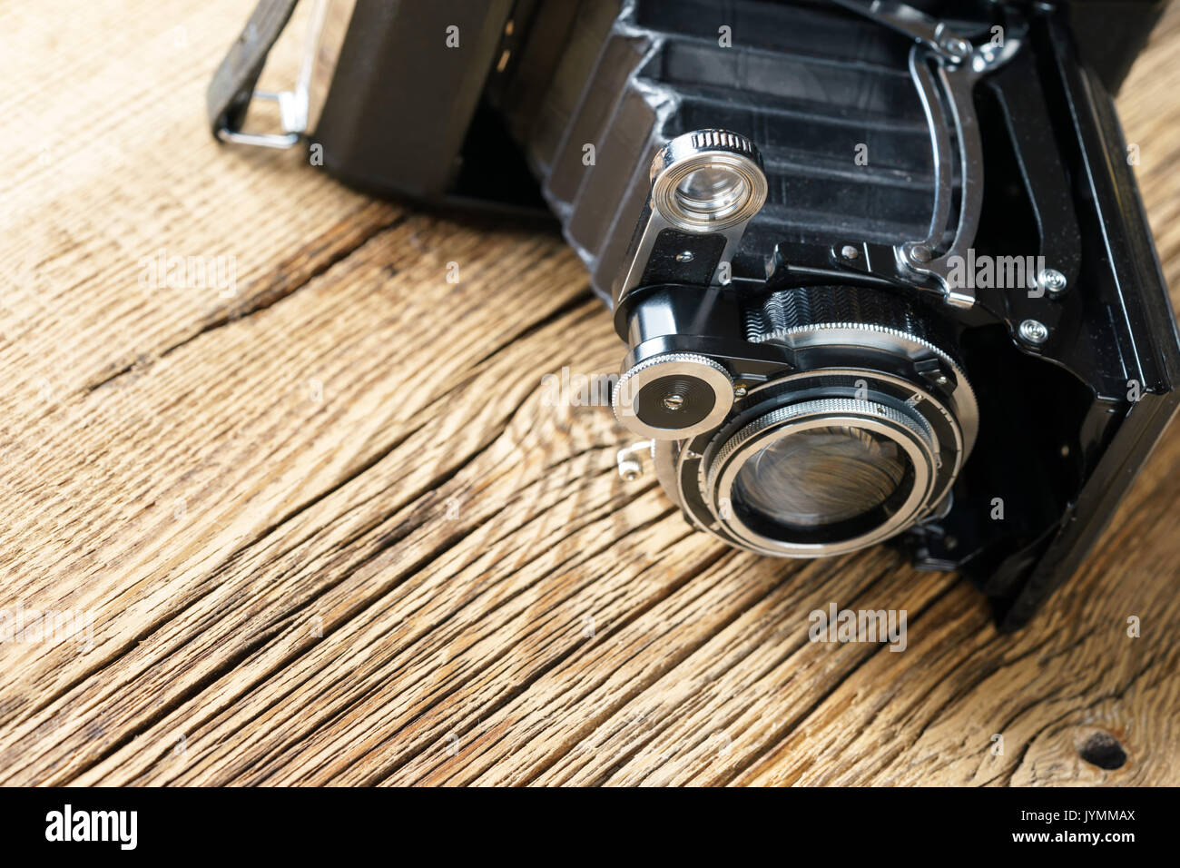 old folding camera on a textured rustic wooden surface Stock Photo - Alamy