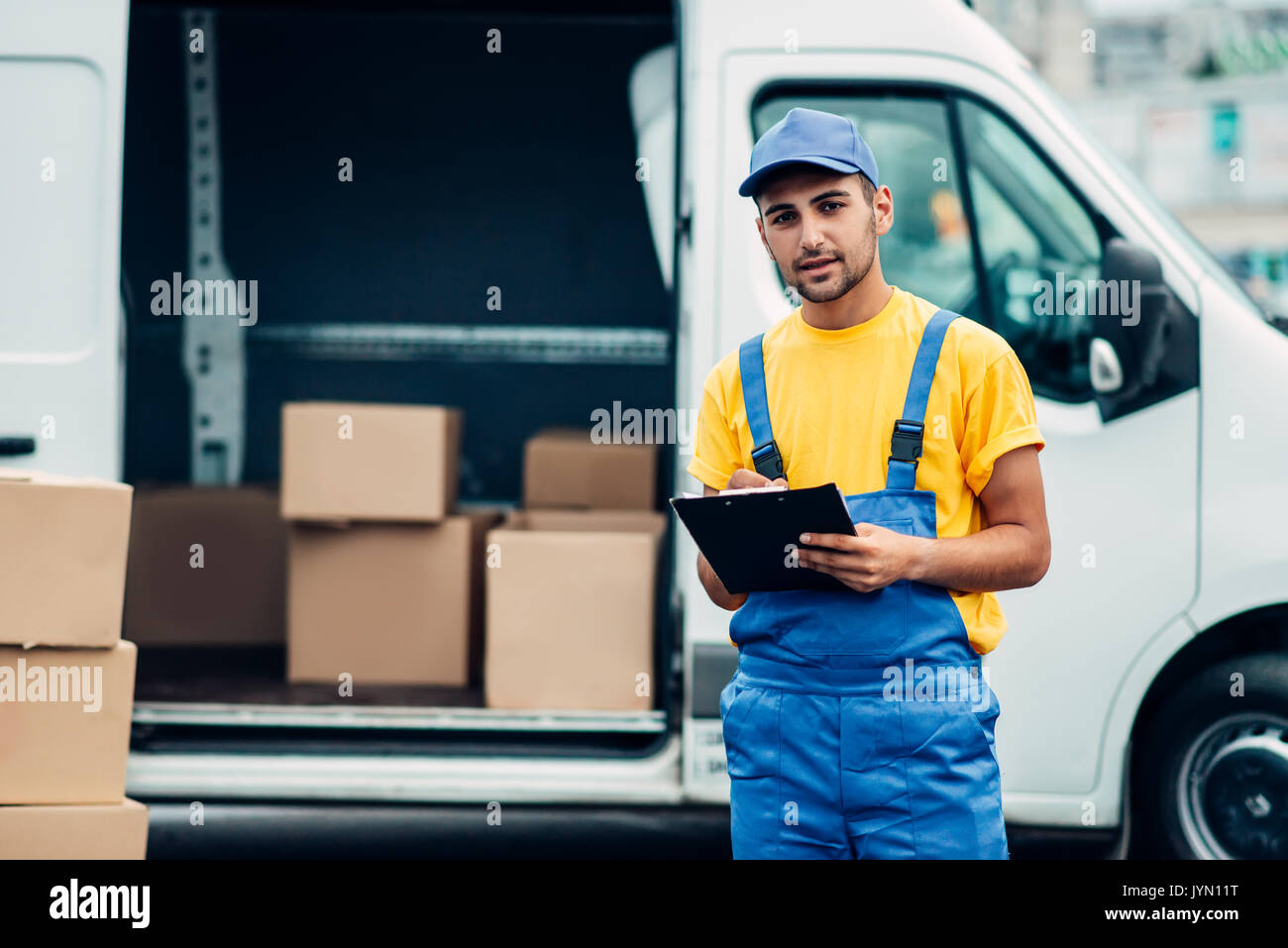 Cargo delivery service, male courier in uniform with box in hand ...