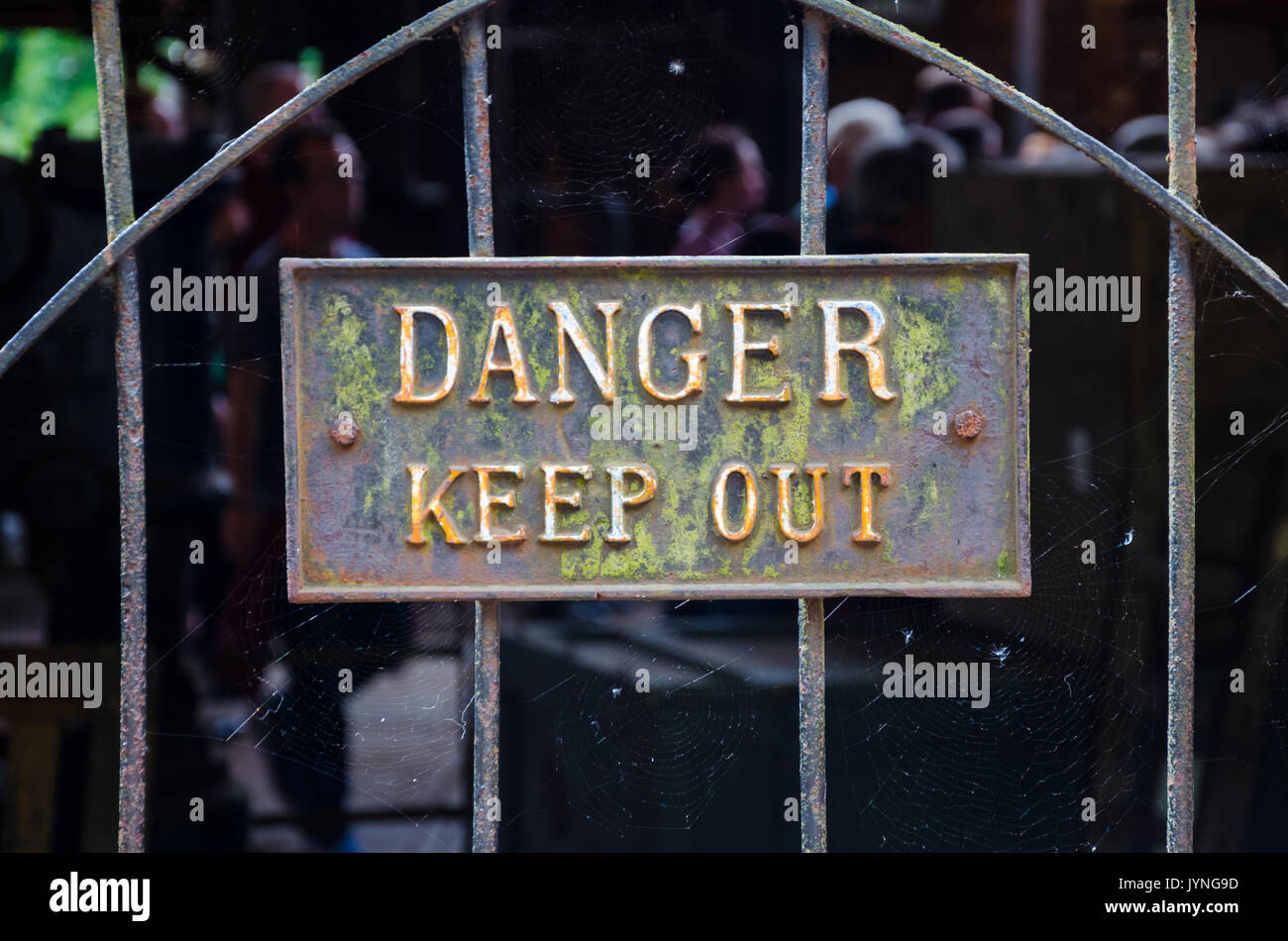 A metal sign on a gate indicating that people should keep out Stock ...