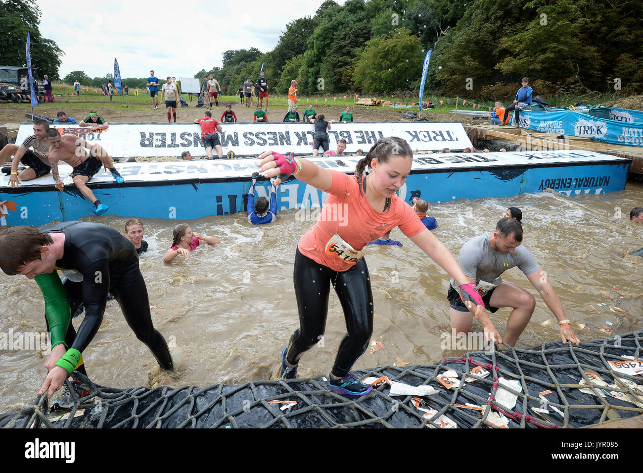 Competitors climb out from a pool filled with rotating blocks in the ...