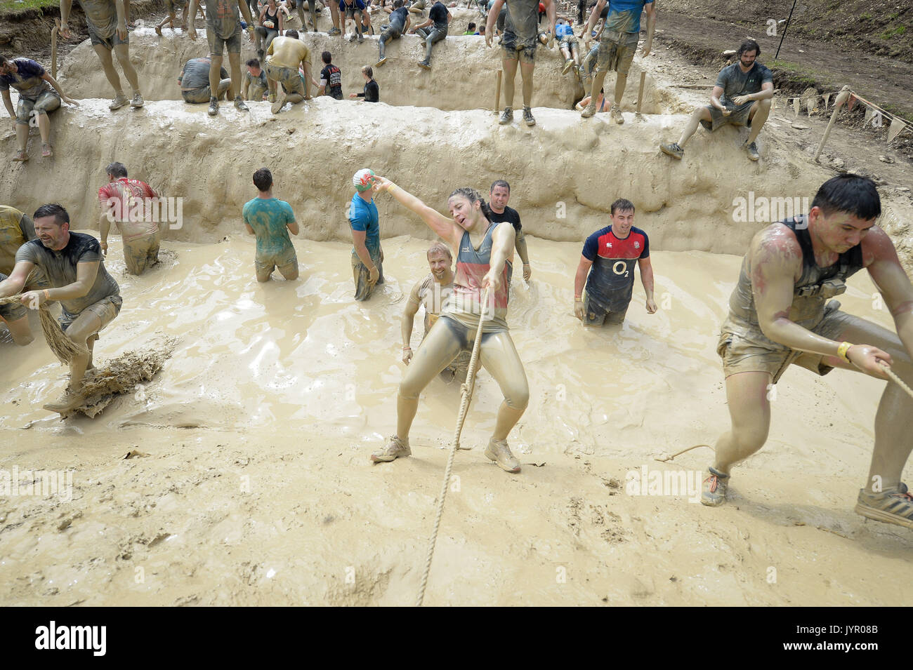 Competitors are covered in mud as they traverse the 'mud mile' obstacle ...