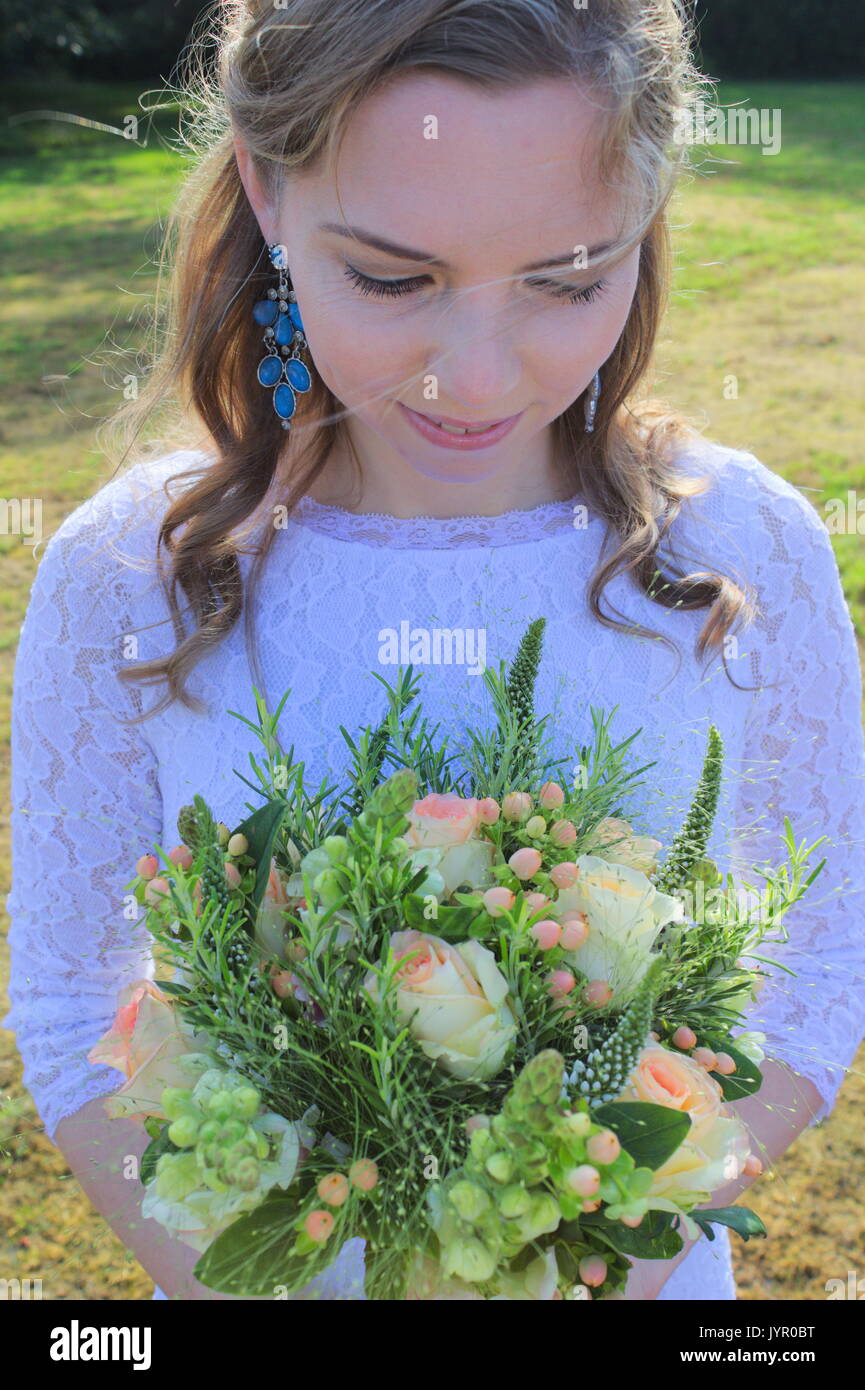 Bride looking at flowers Stock Photo - Alamy