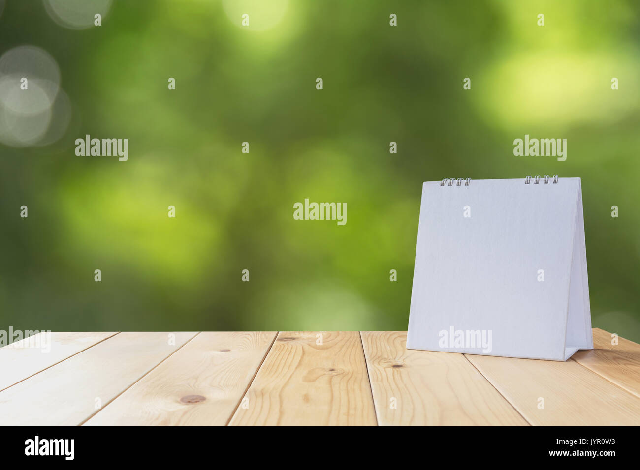 White calendar on wood table on nature background and copy space mock ...