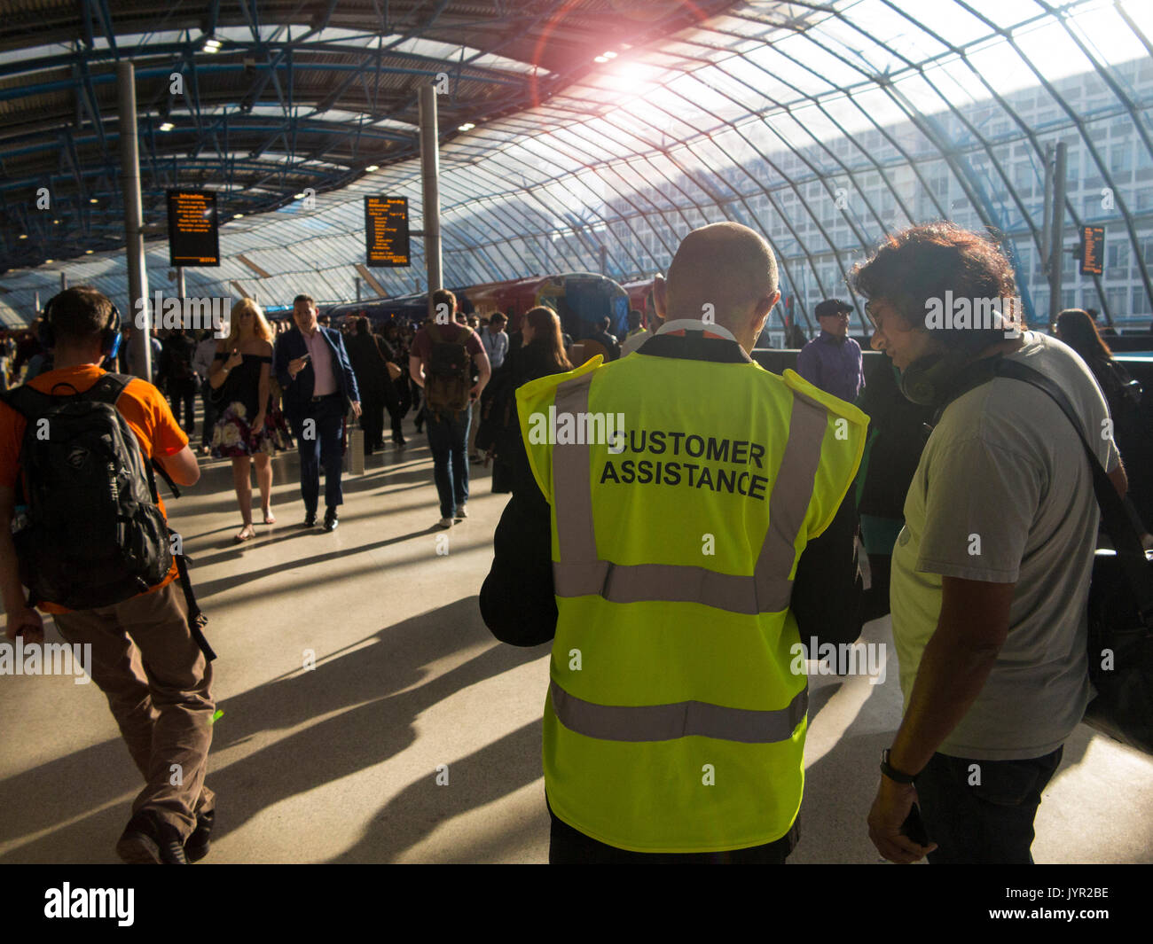An official employee offers assistance to a commuter at Waterloo ...