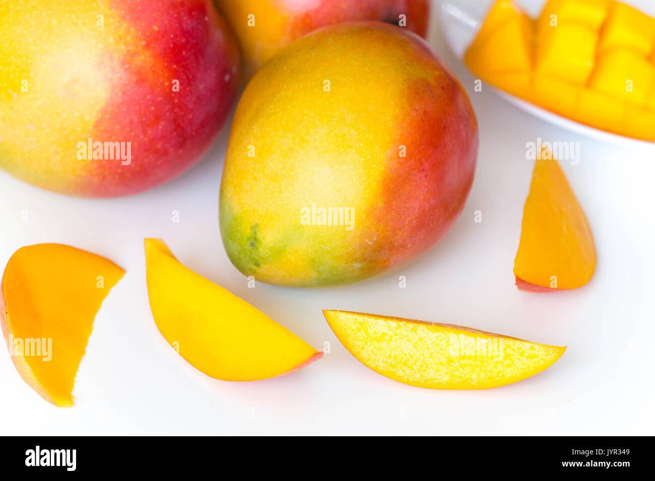 Fresh mango, whole and cut to eat shown on a light background Stock ...