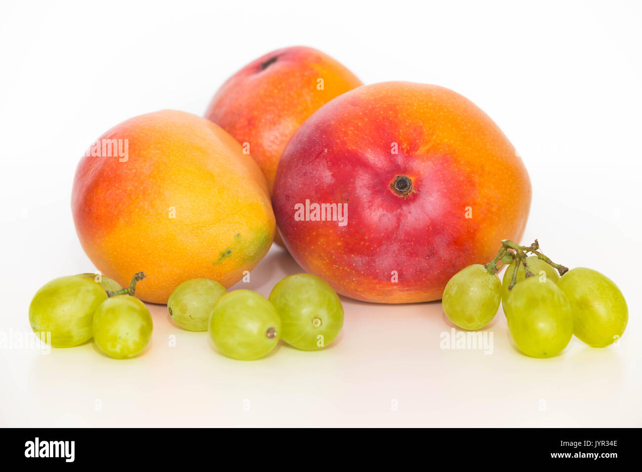 Fresh ripe mango, shown on a light background with grape balls Stock ...