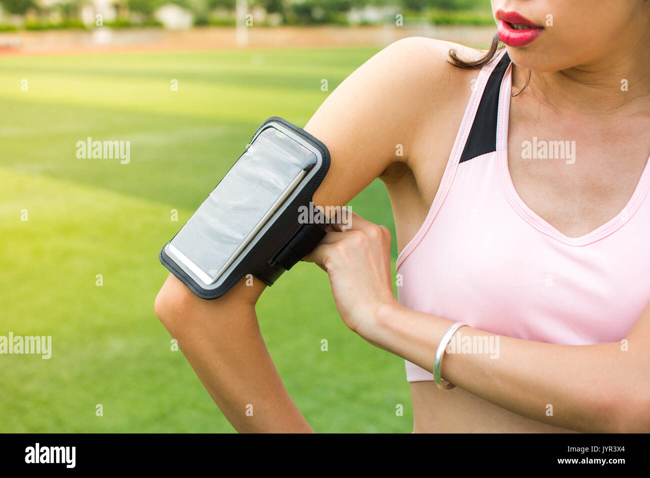 Girl setting up smartphone to track jogging sport activity Stock Photo ...