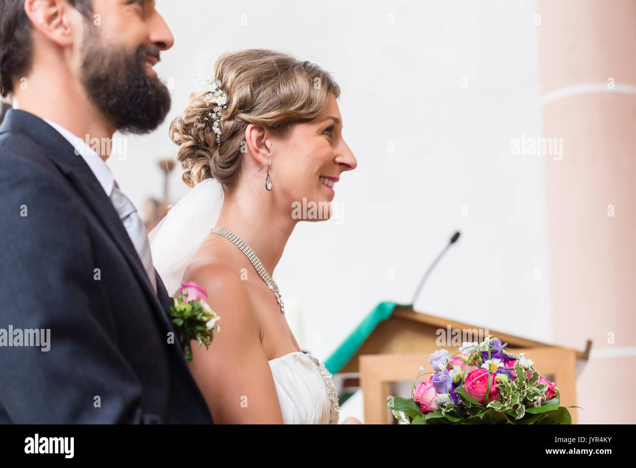 Bride and groom having wedding in church at altar Stock Photo - Alamy