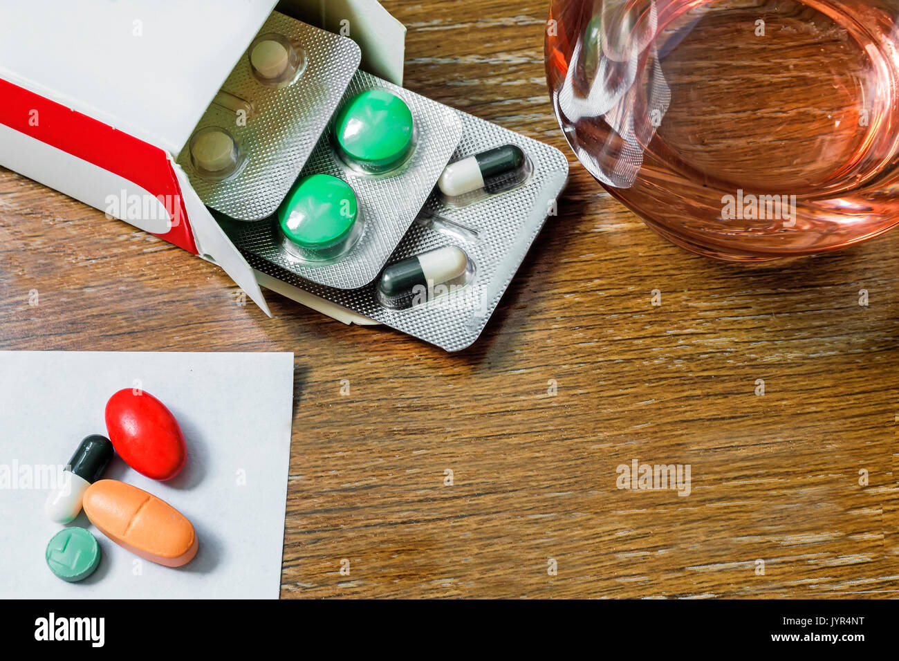 On the table are several types of pills and vials. Standing next to a ...